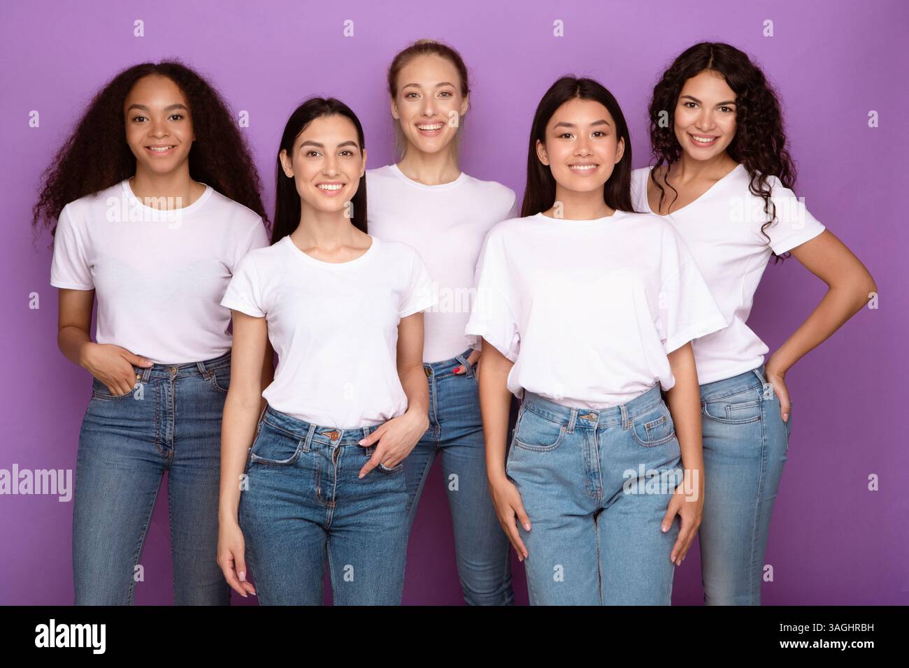 Pretty Diverse Women Standing Over Purple Studio Background Stock Photo ...