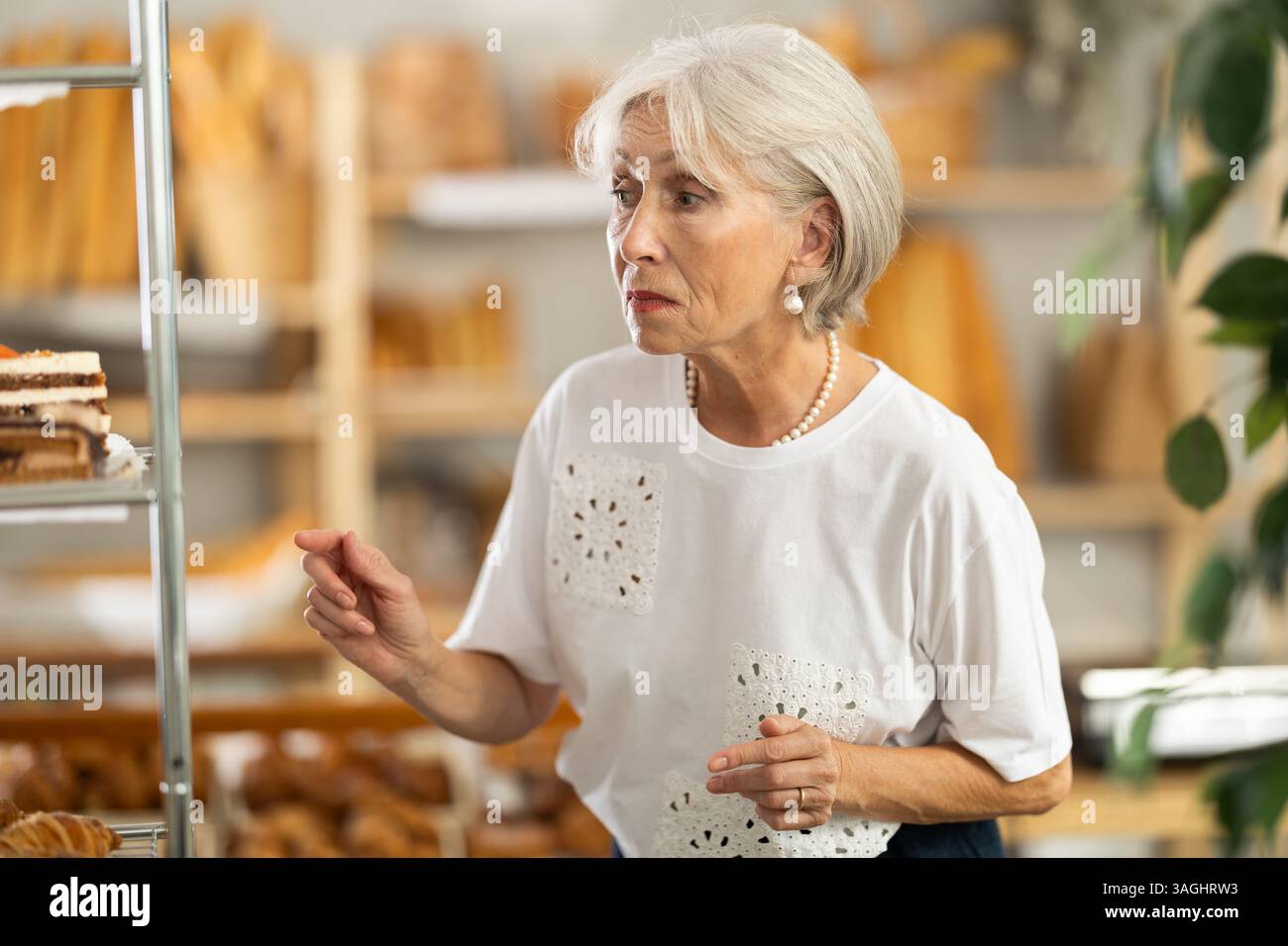 Old female customer chooses something in bakery Stock Photo - Alamy