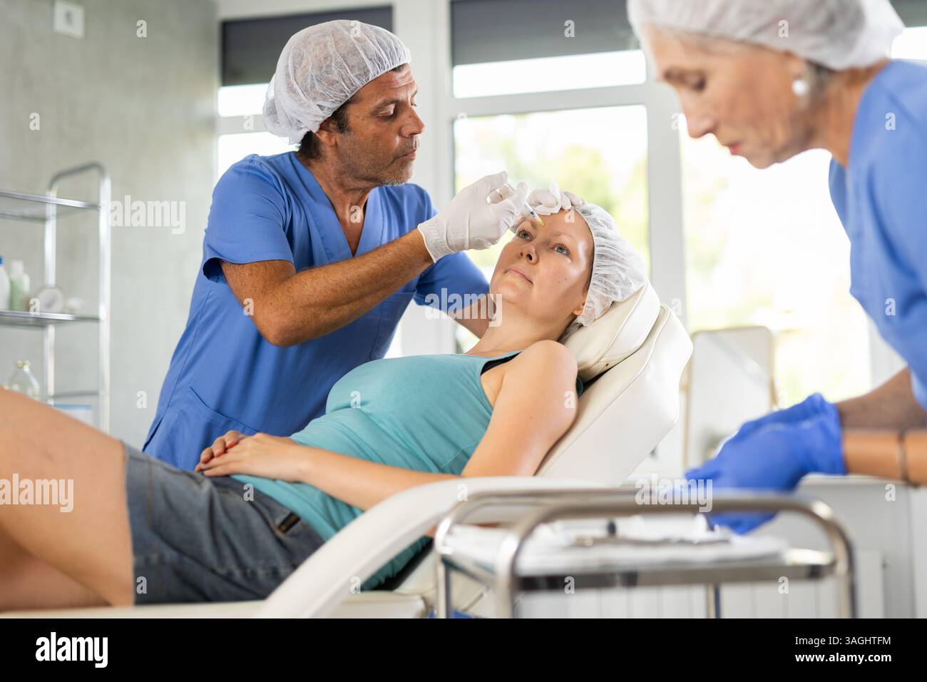 Male doctor with nurse help gives injection of botulinum toxin to ...