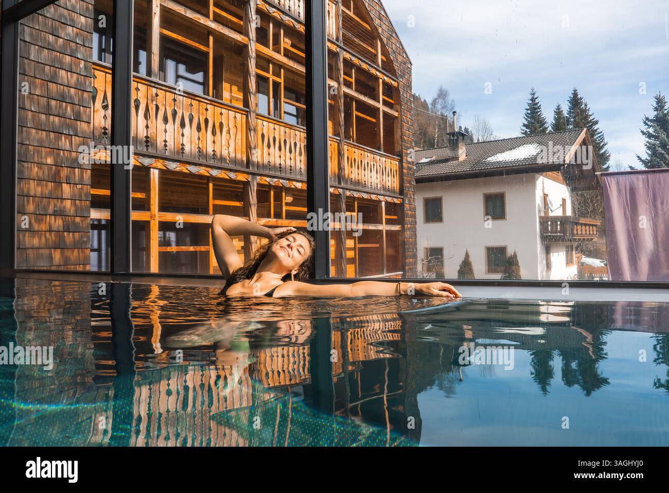 Woman Relaxing in Indoor Infinity Pool with Alpine Chalet View Stock ...
