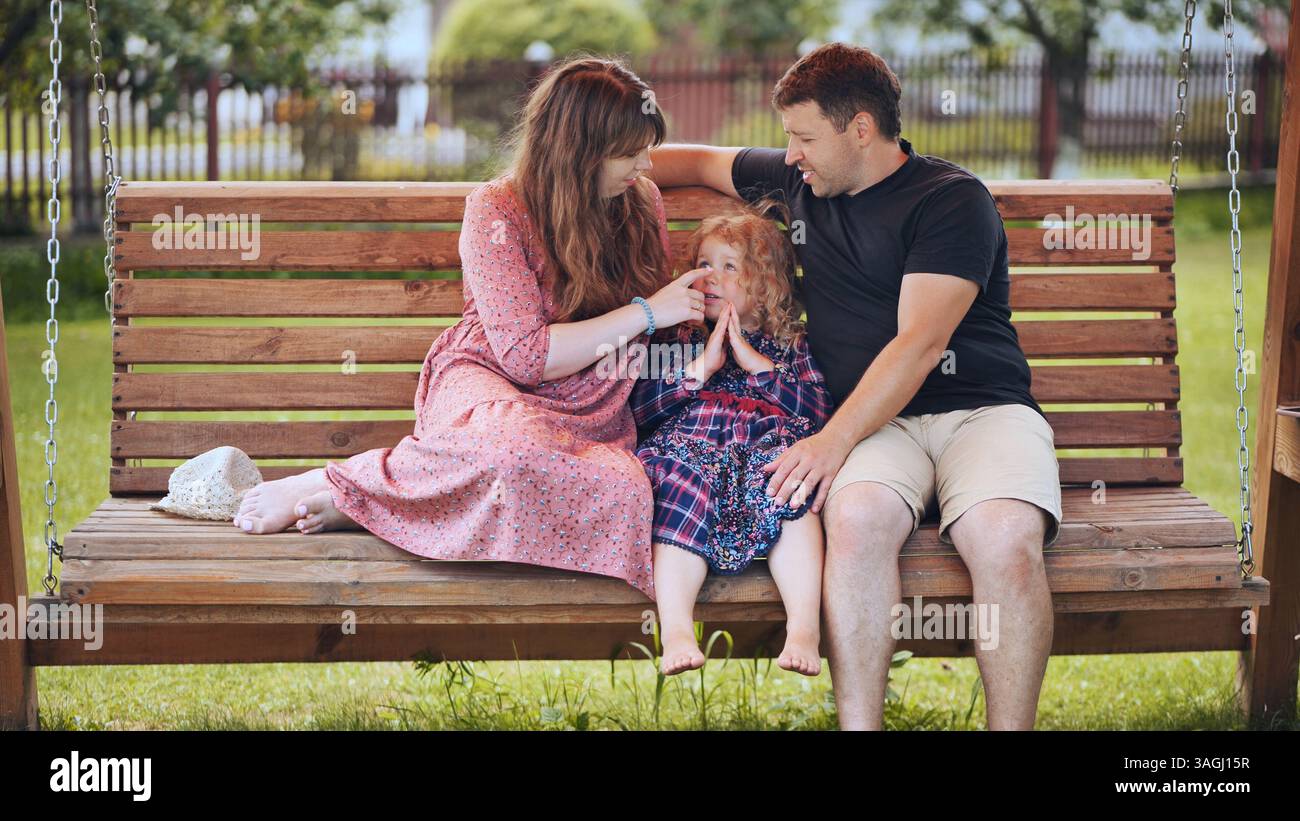Family enjoying sunny backyard moment, parents and child bonding on ...