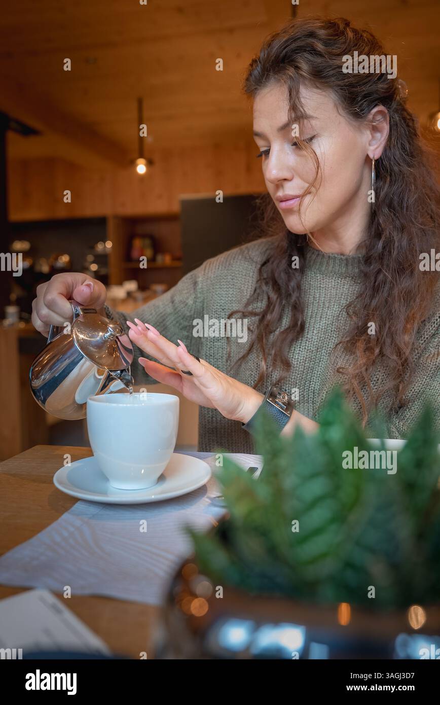 Woman Pouring Liquid into Cup in Elegant Wooden Interior Setting Stock ...