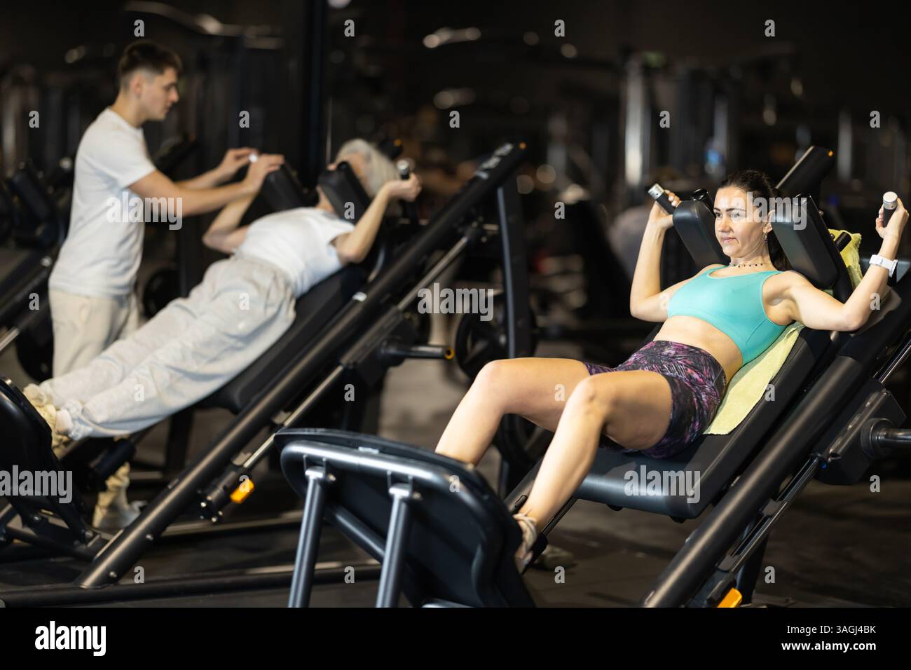 Woman performing hack squats in modern gym Stock Photo - Alamy