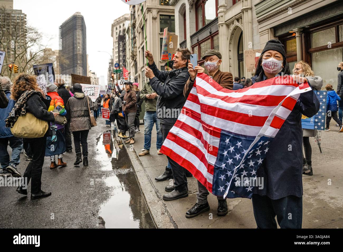 Protesters hold upside-down American flags during the Hands Off ...