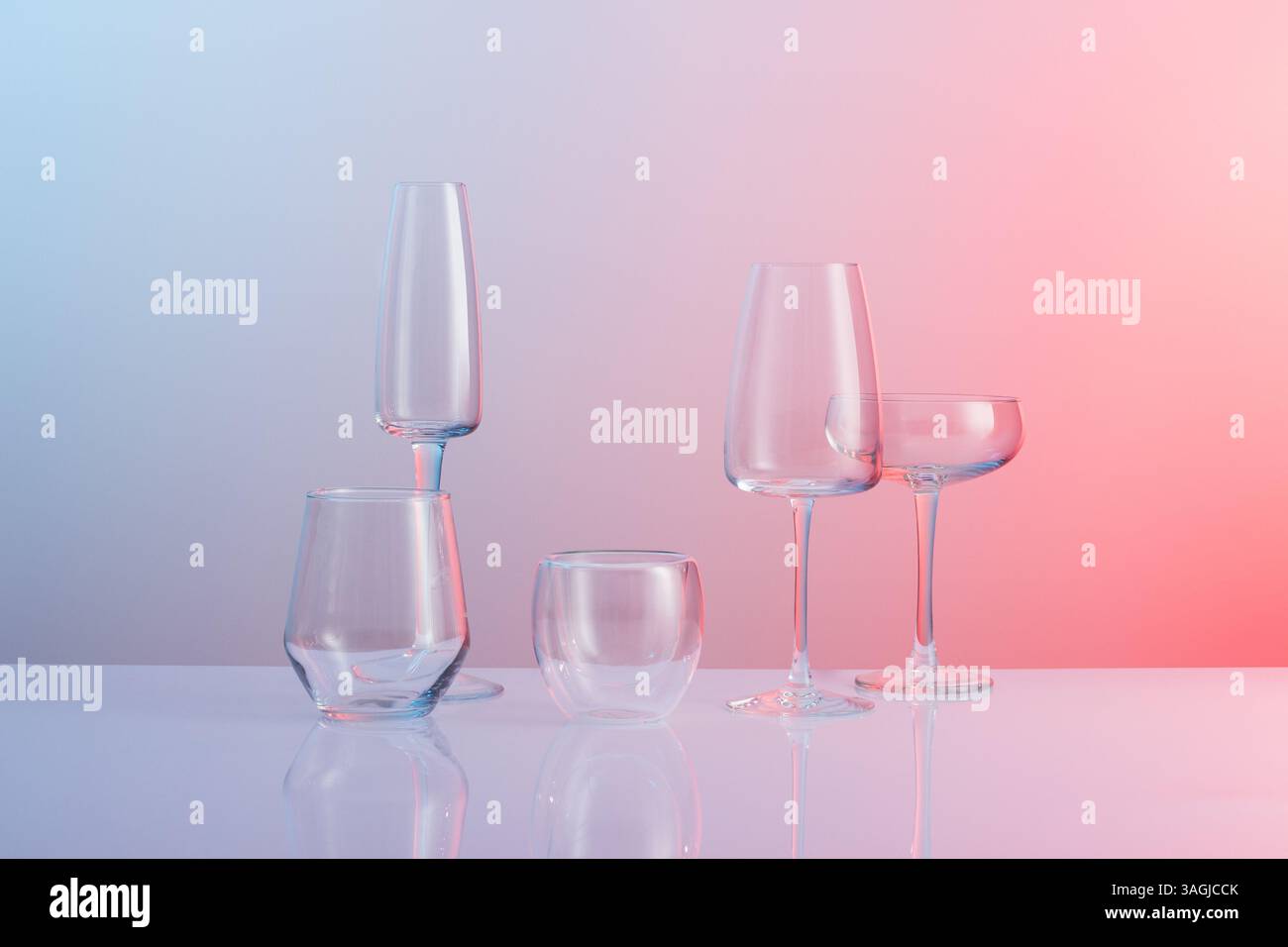 Glassware on a pink and blue gradient background Stock Photo - Alamy