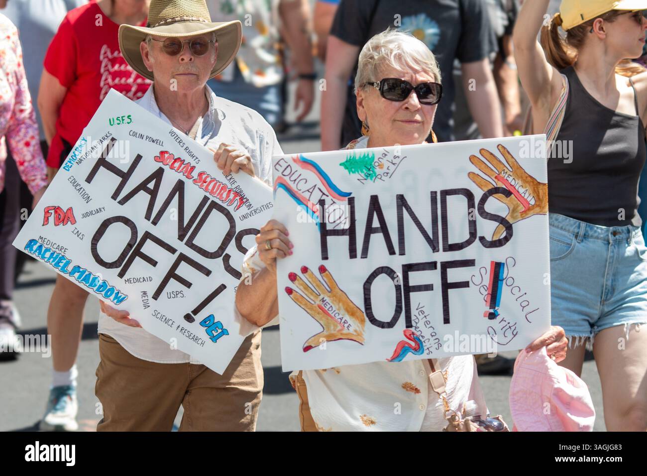 Atlanta, GA / USA - April 5, 2025: Elderly couple marches while holding ...
