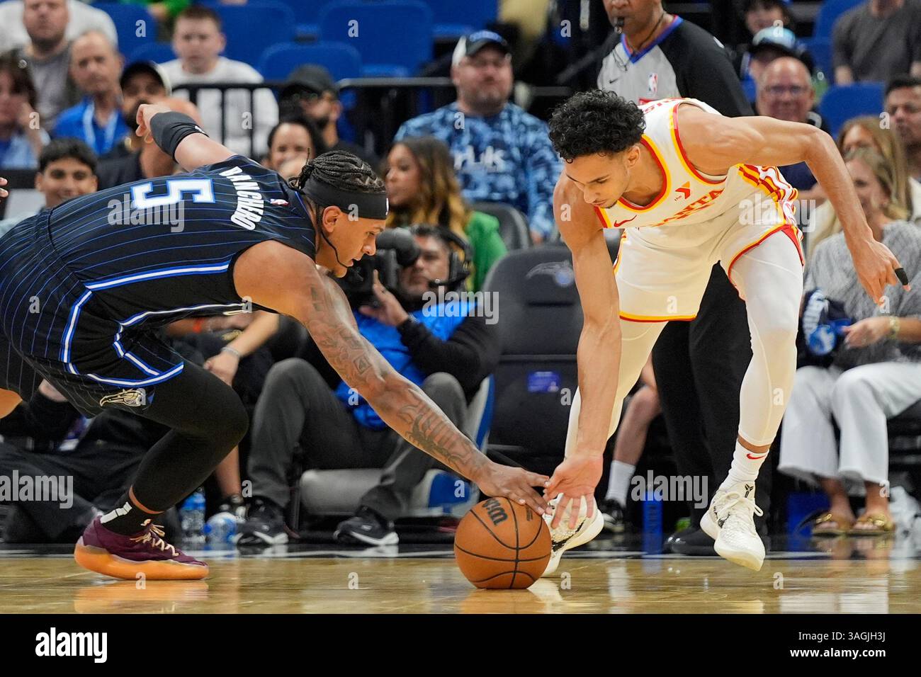 Orlando Magic forward Paolo Banchero (5) goes after a loose ball against Atlanta Hawks forward ...