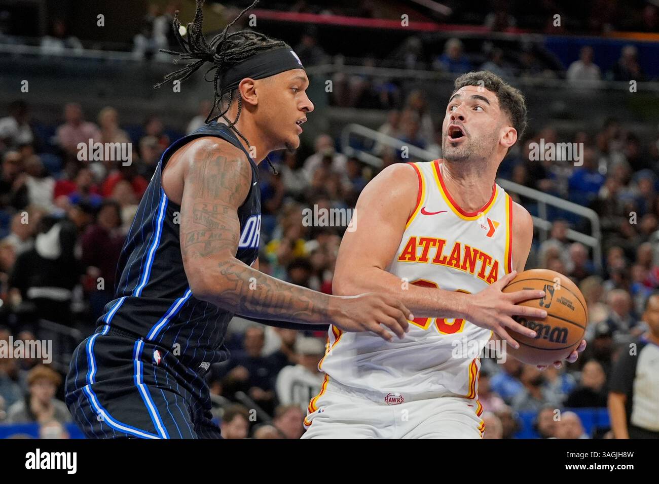 Atlanta Hawks forward Georges Niang, right, looks for a shot against Orlando Magic forward Paolo ...