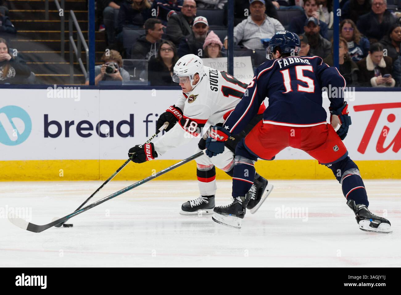 Ottawa Senators' Tim Stutzle, left, tries to skate past Columbus Blue ...