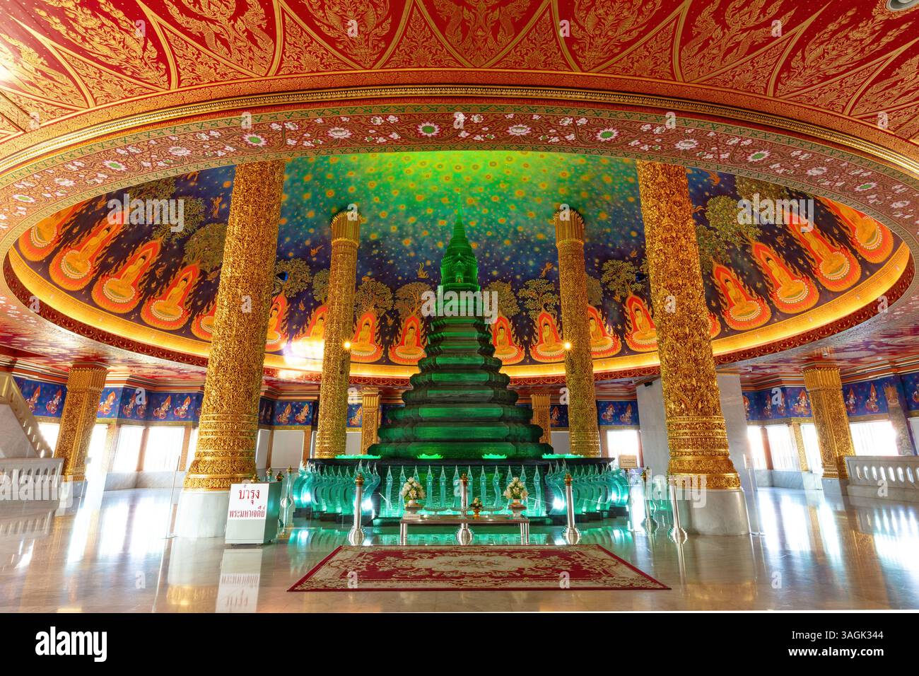 Emerald green glass pagoda surrounded by intricately decorated golden ...