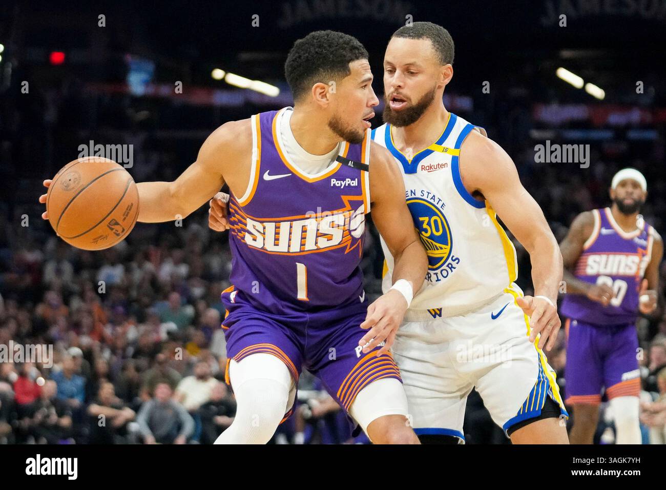 Phoenix Suns guard Devin Booker (1) is guarded by Golden State Warriors guard Stephen Curry ...