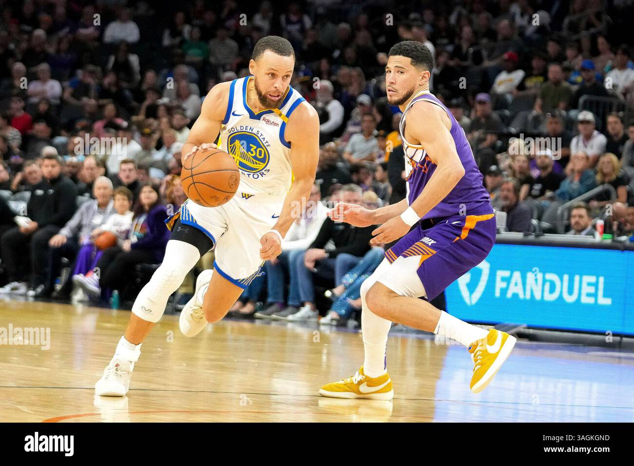 Golden State Warriors guard Stephen Curry (30) drives around Phoenix Suns guard Devin Booker (1 ...