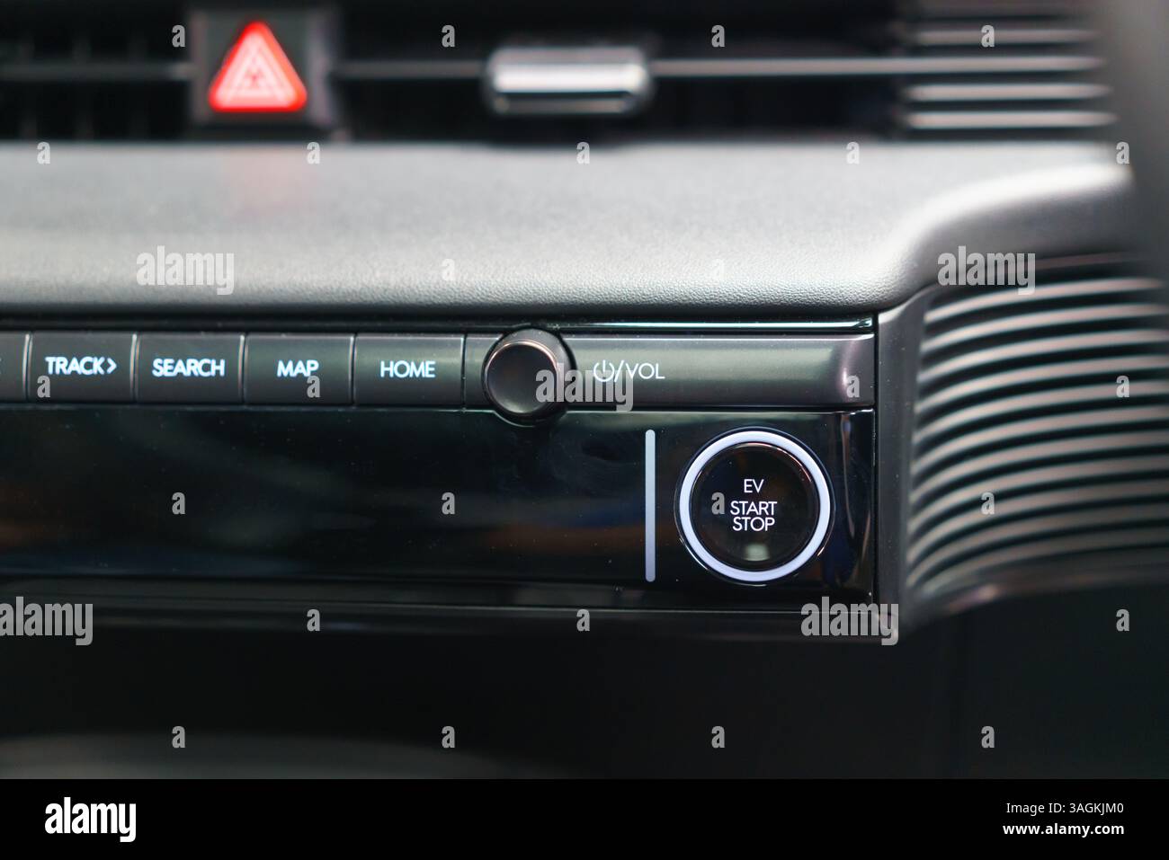 modern EV start-stop button beside a volume control knob on a sleek ...