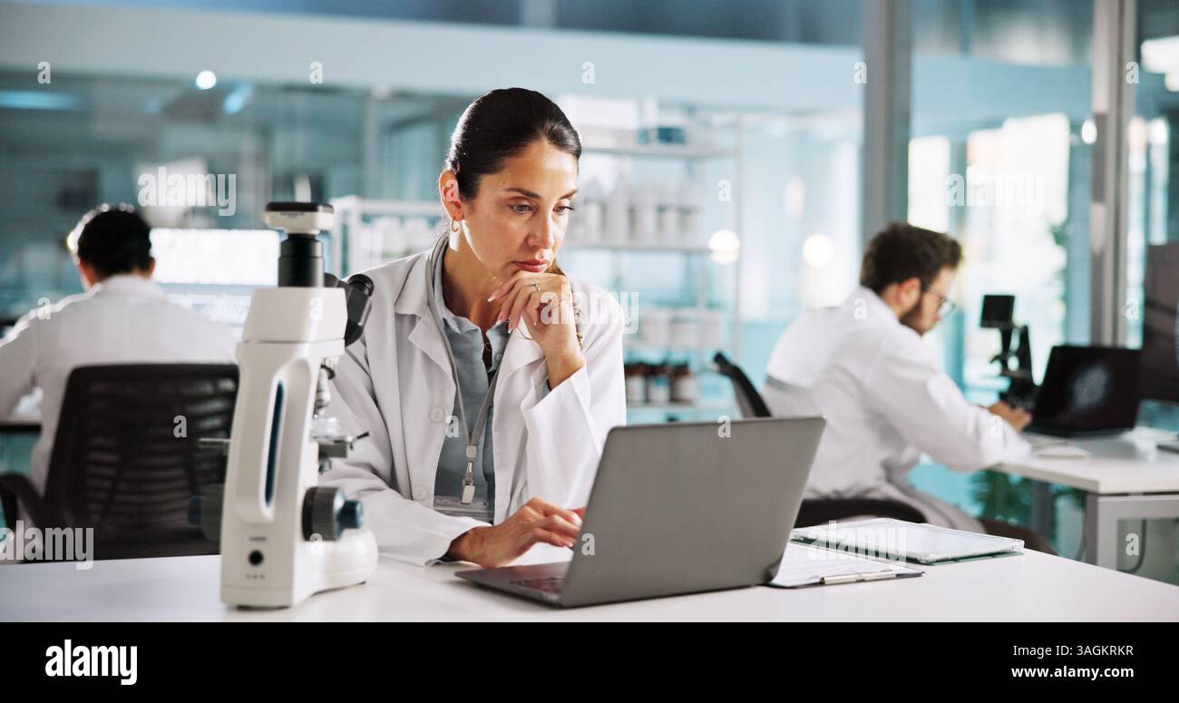 Thinking, laptop and reading with woman in laboratory for clinical ...