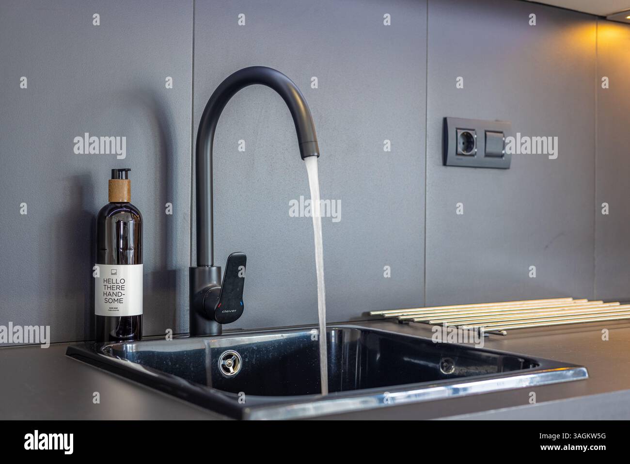 Modern kitchen interior featuring a matte black sink and faucet, water ...