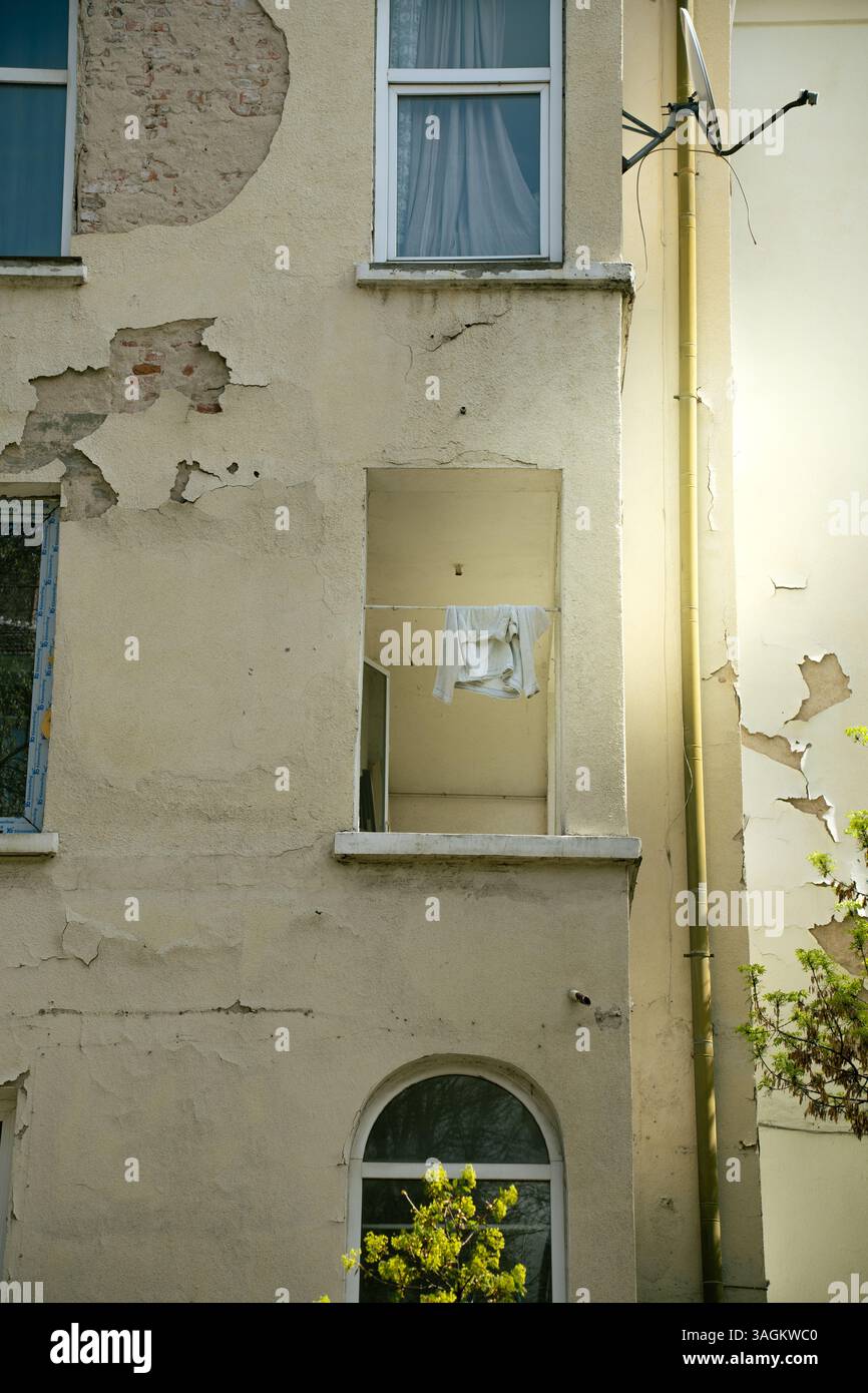 Urban apartment facade with peeling paint and damaged plaster ...