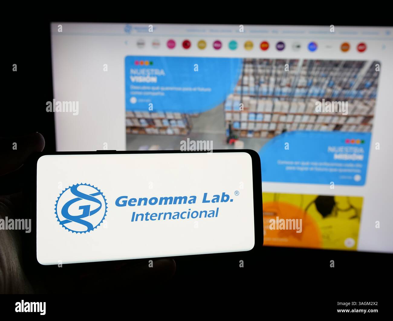 In this photo illustration, a person is holding a smartphone with the logo of company Genomma ...