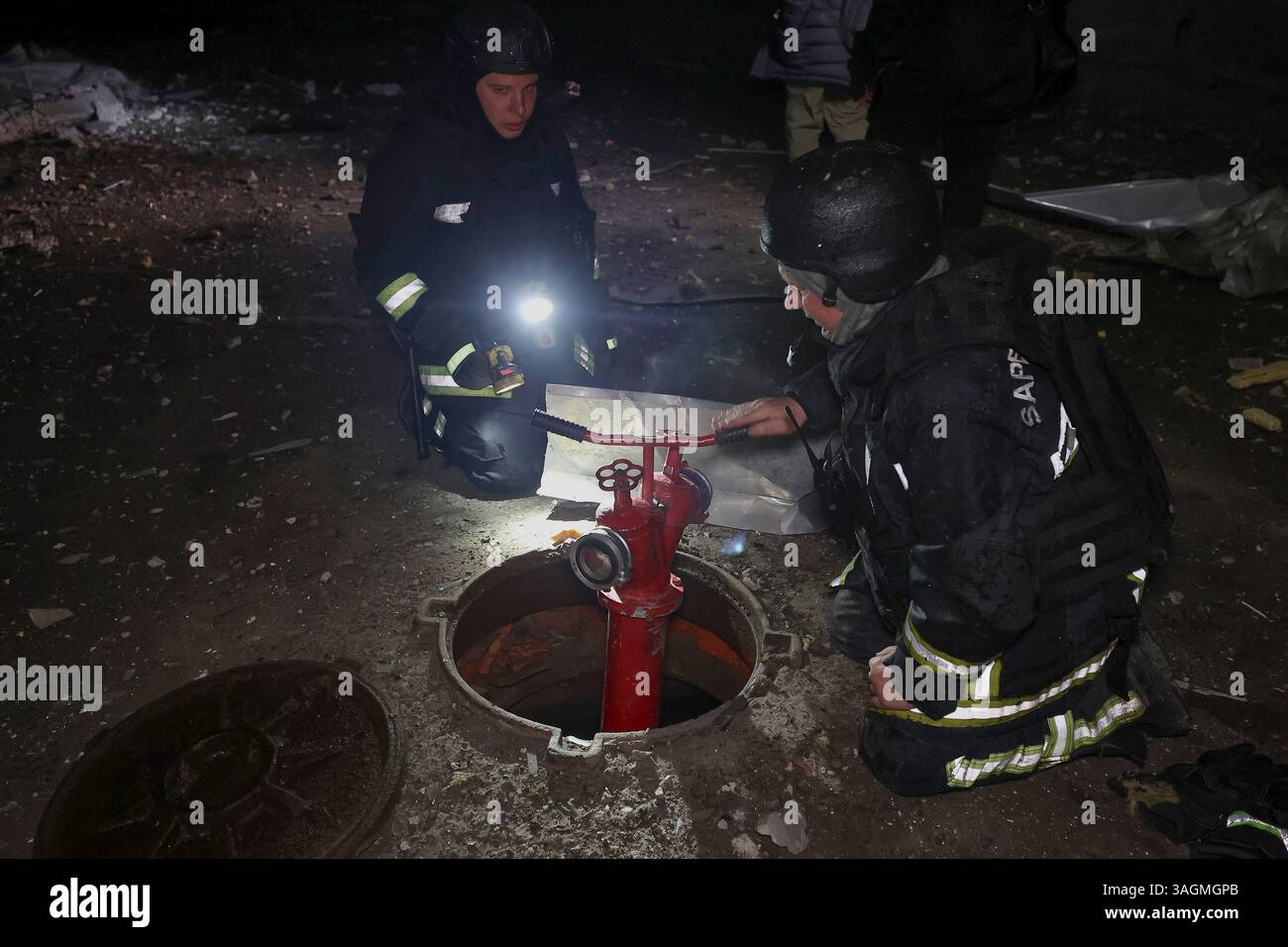 Two firefighters reach for a fire hydrant during a response effort to a ...