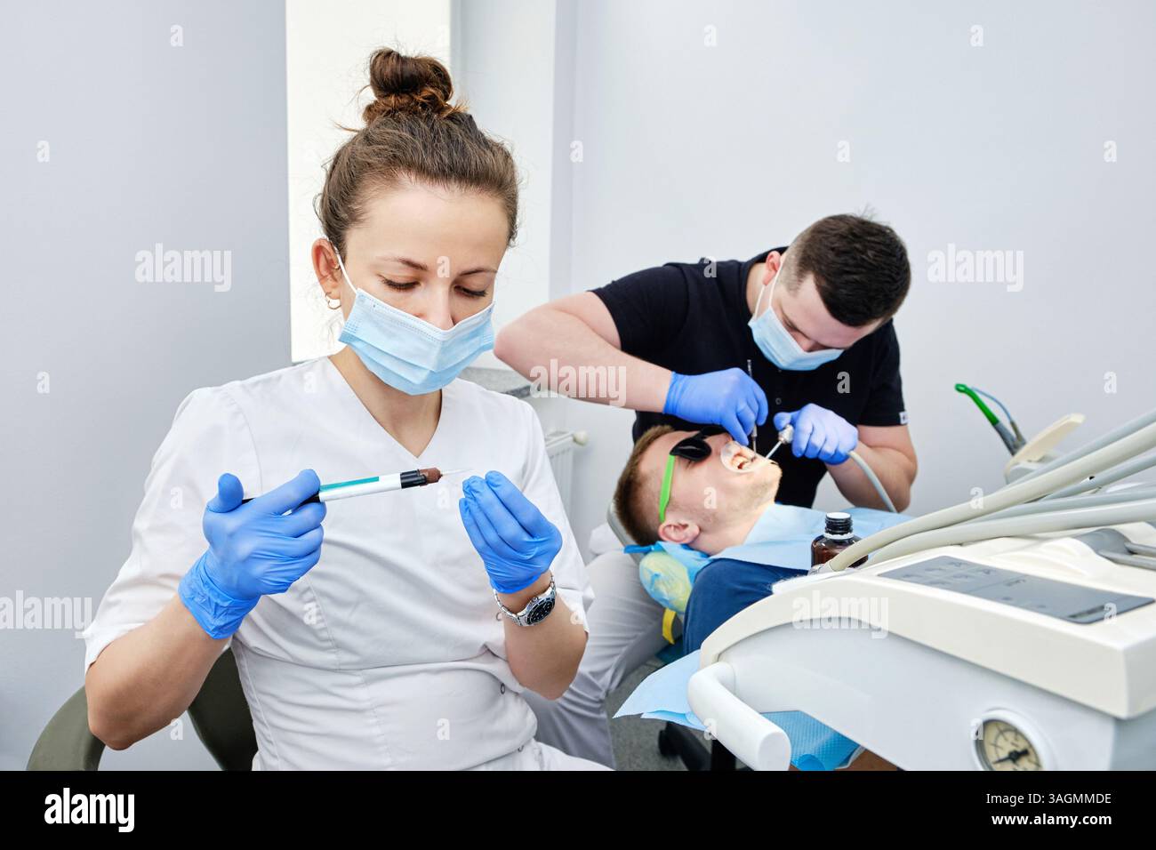 Dentist and Assistant Cementing Crown. Installing a dental crown ...