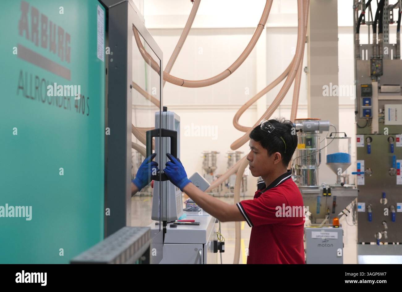 A worker operates a moulding machine at Lego factory in Binh Duong ...