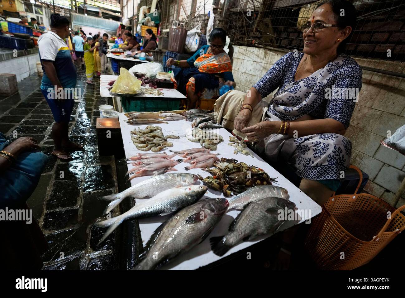 Fish vendors await customers at a fish market in Mumbai, India ...