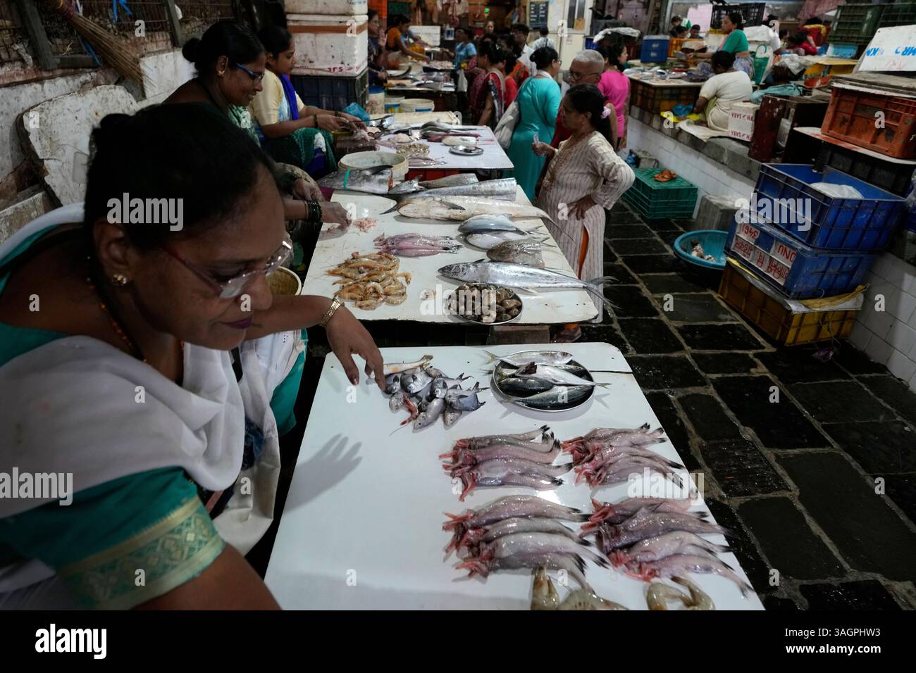 Fish vendors await customers at a fish market in Mumbai, India ...