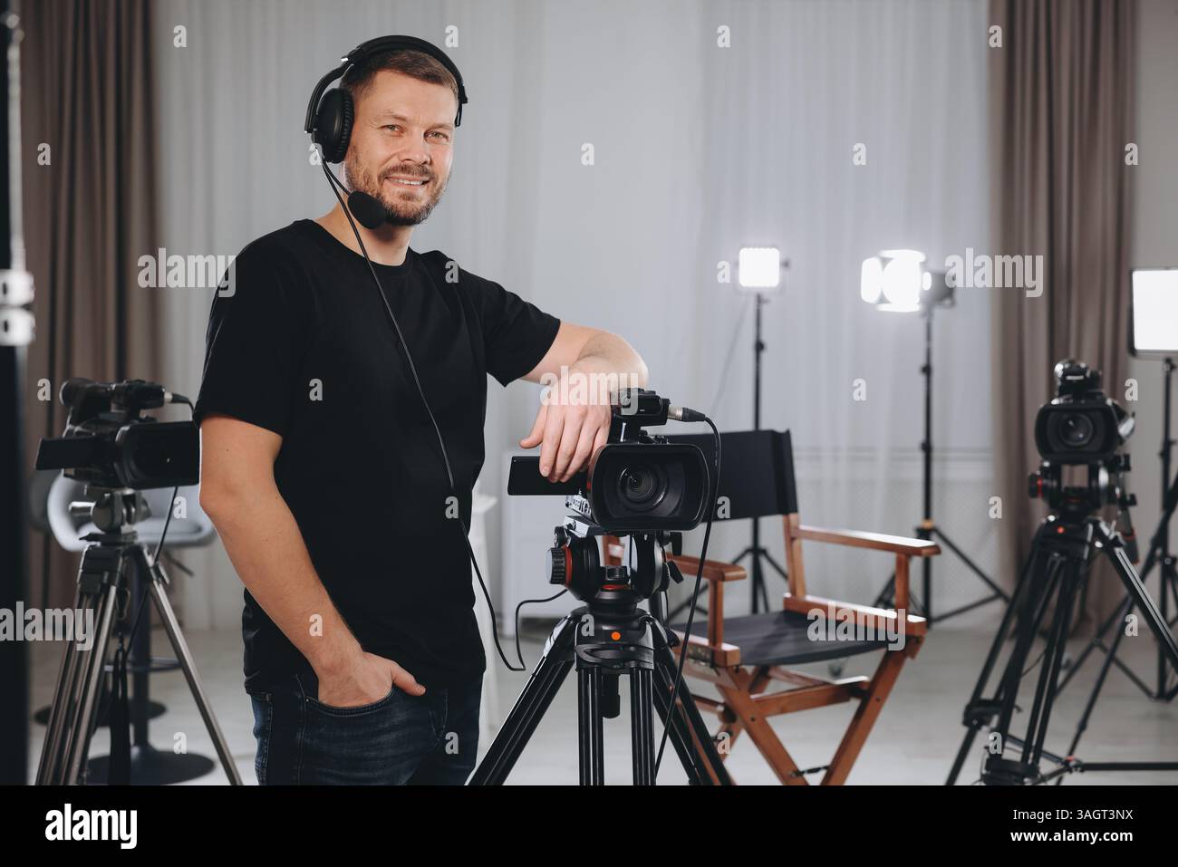 Cameraman with camera and headphones in film studio Stock Photo - Alamy