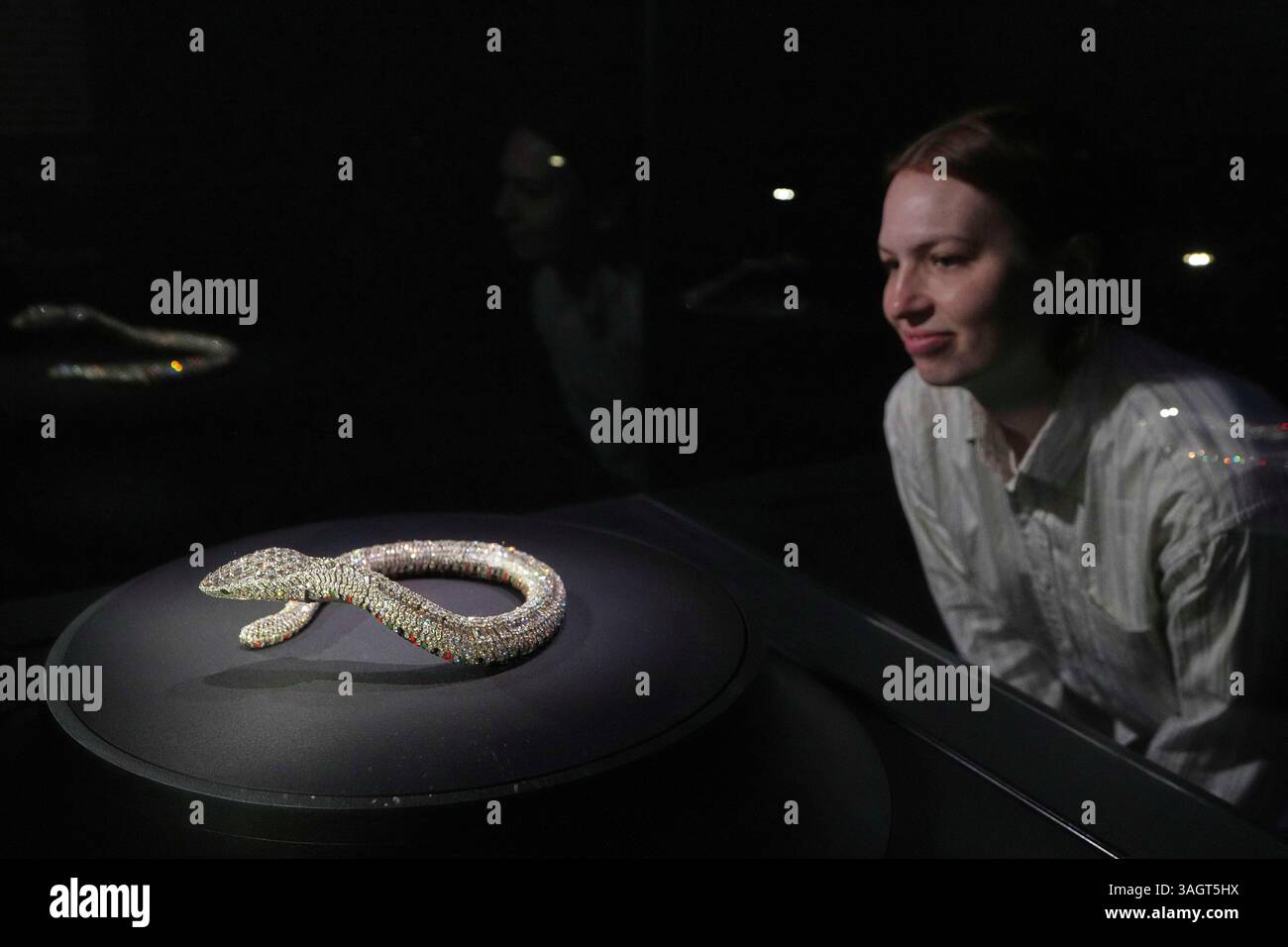 A museum employee looks towards a snake necklace commissioned by ...