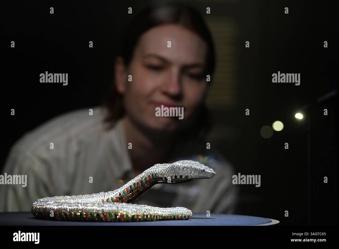 A museum employee looks towards a snake necklace commissioned by ...