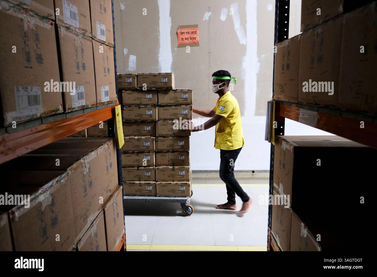 A worker transports boxes of garments produced at a factory run by the Bangladesh based Urmi ...