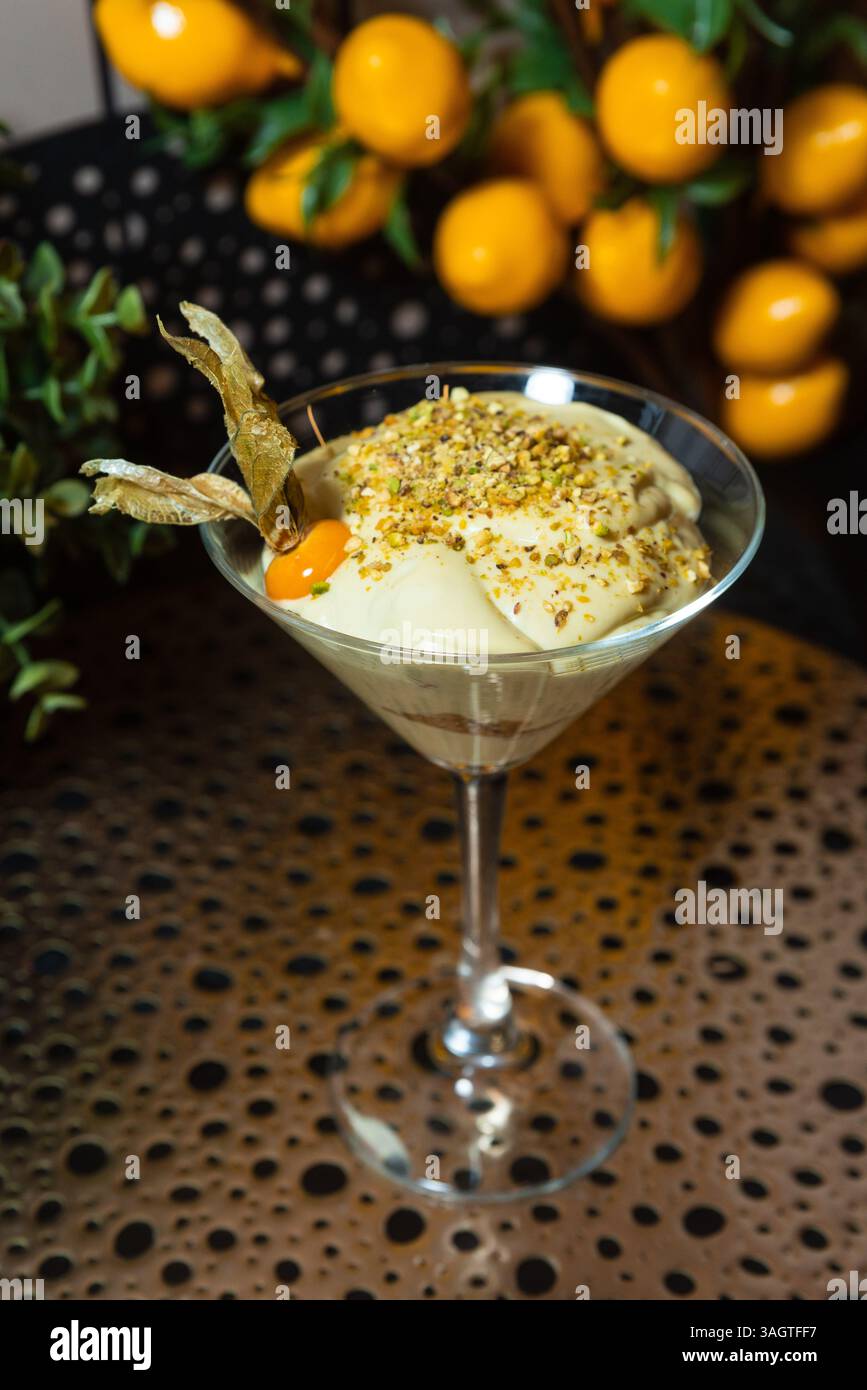 Creamy pistachio mousse served in a cocktail glass, topped with chopped ...