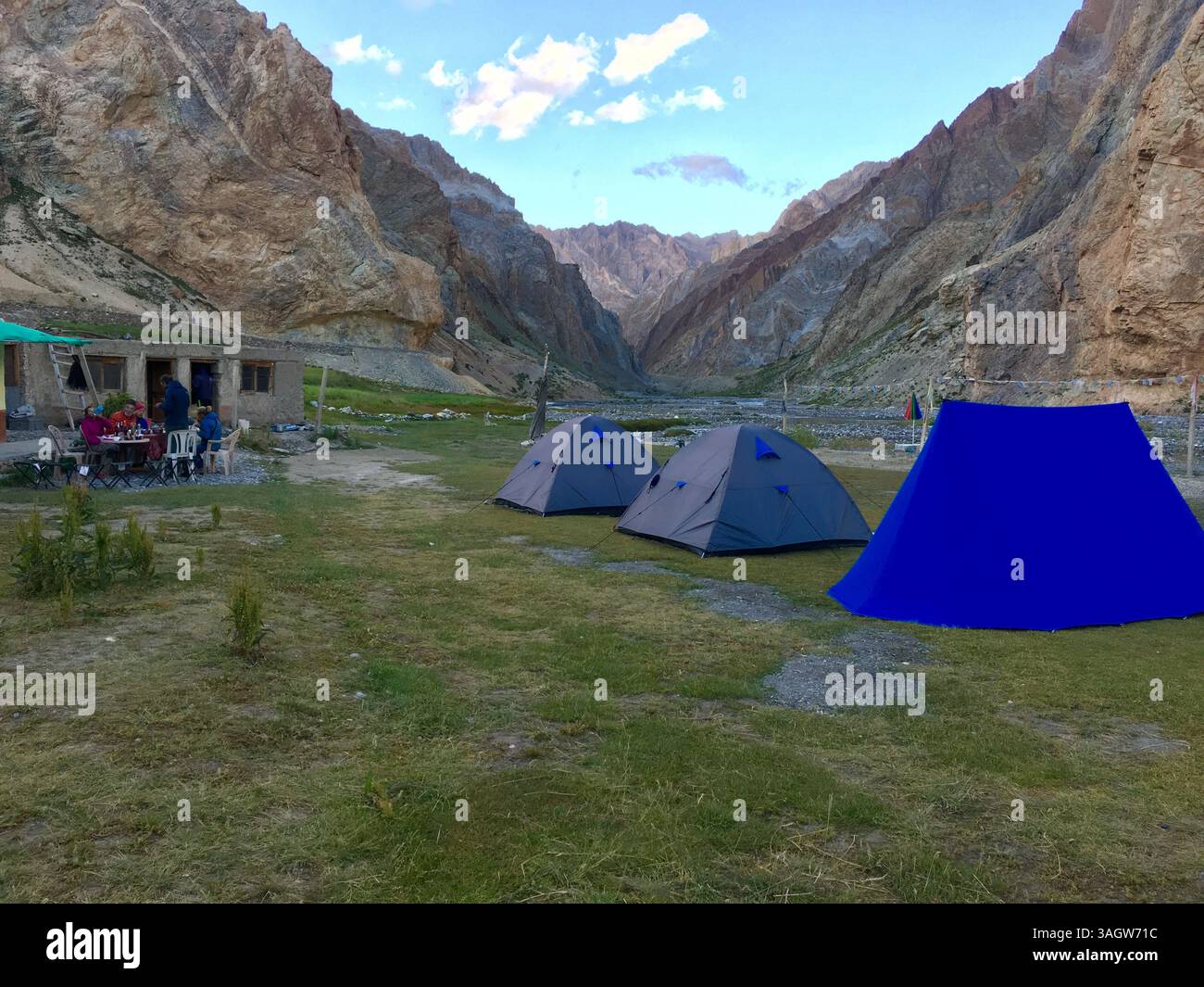 Camping setup with tents placed in a lush green valley of Leh Ladakh ...