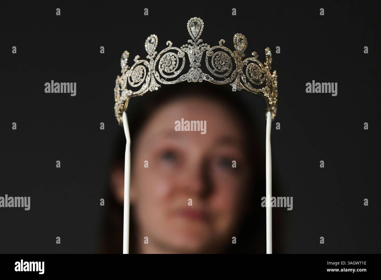 A museum employee looks at a tiarra on display at Cartier – the first ...