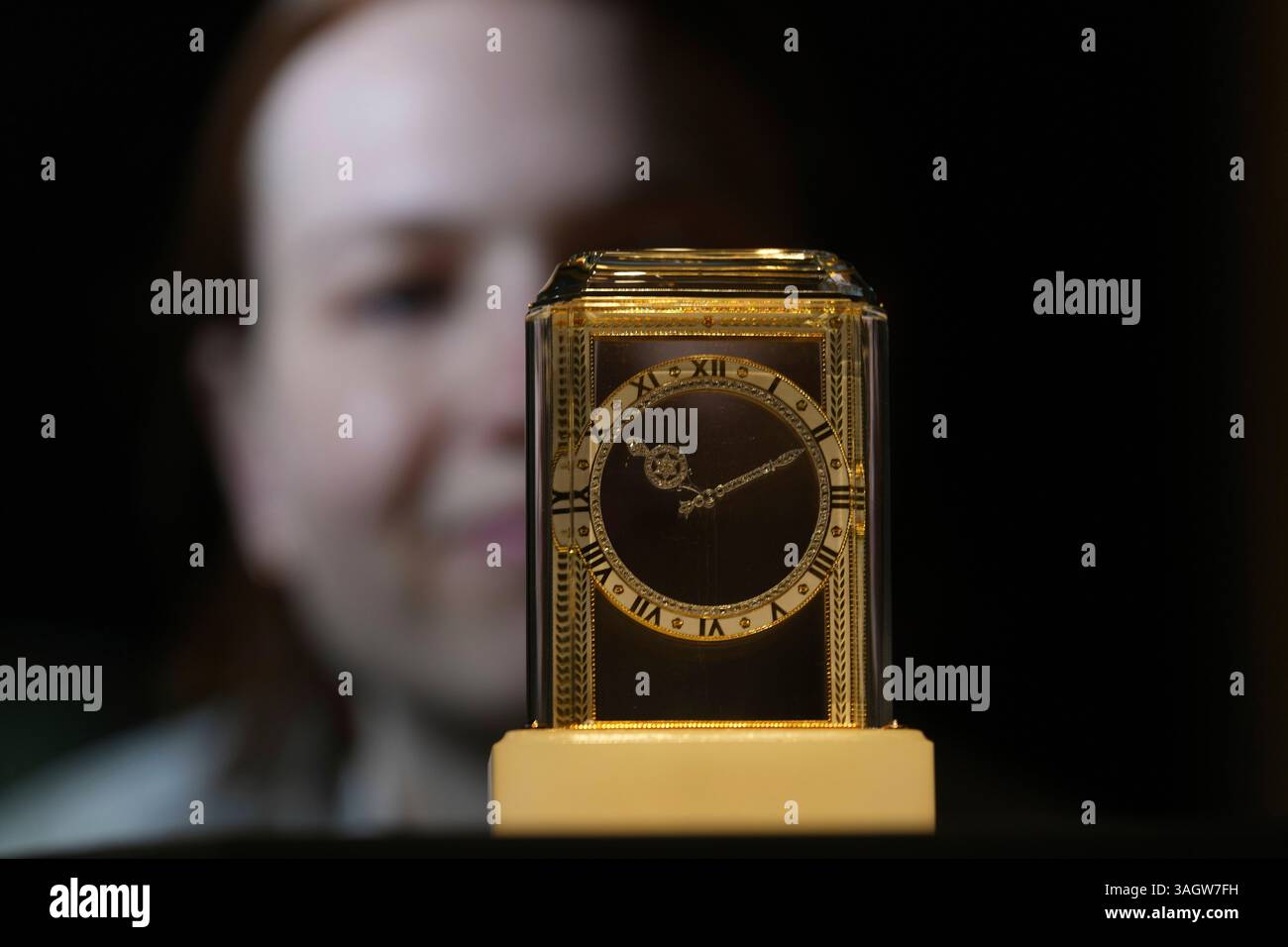 A museum employee looks towards a 1914 clock on display at Cartier ...
