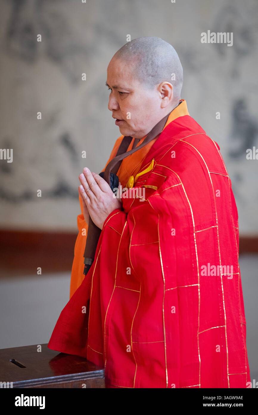 A Quinming service of prayers for the deceased being led by a female ...