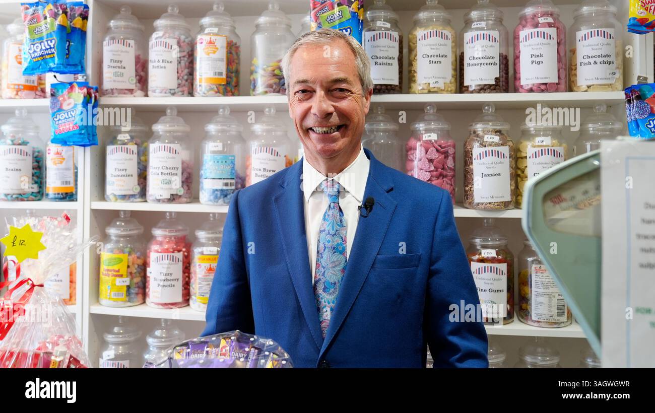 Reform UK leader Nigel Farage poses in a sweet shop during a walkabout ...