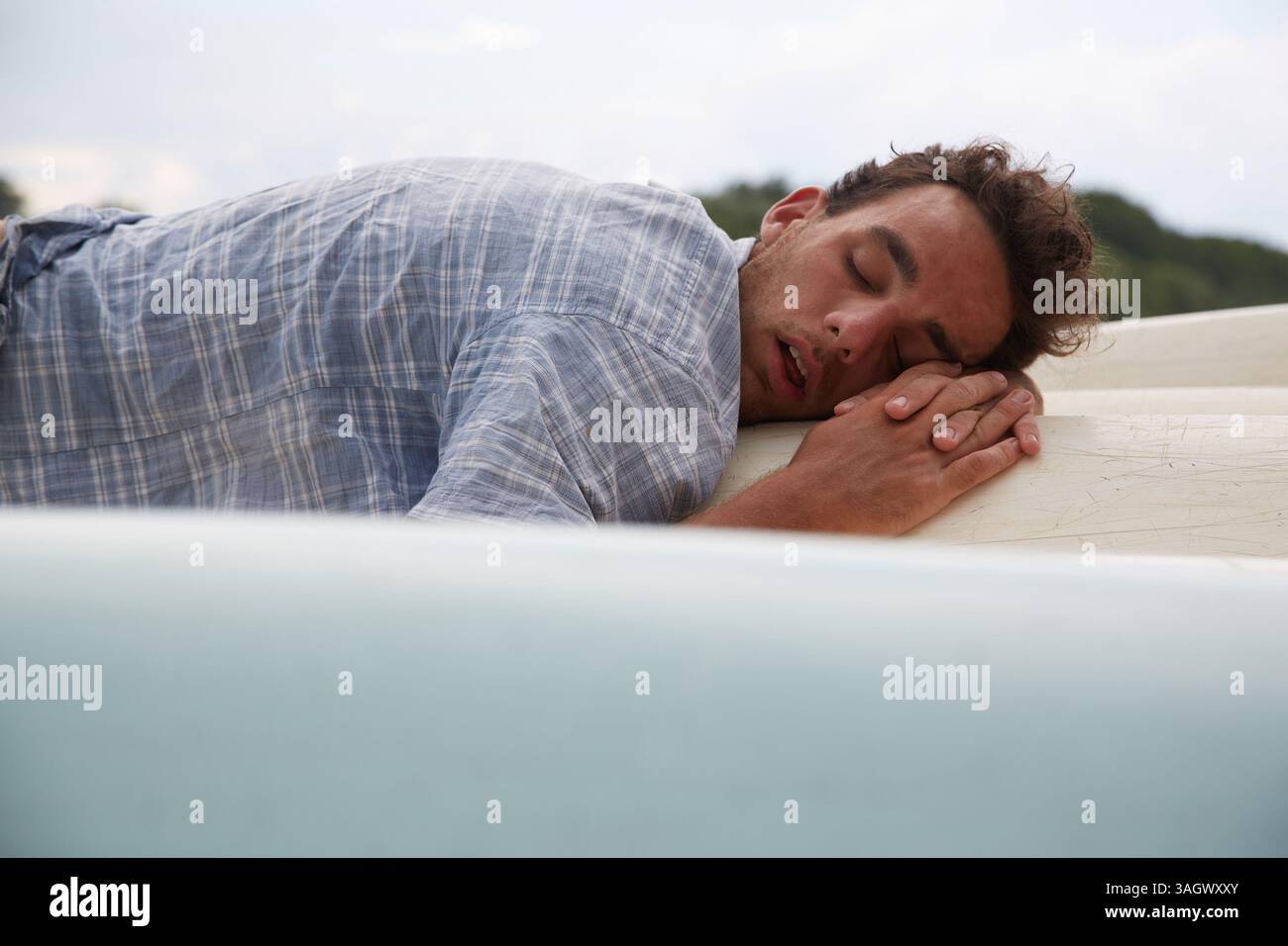 Man sleeping on the bottom of canoes Stock Photo - Alamy