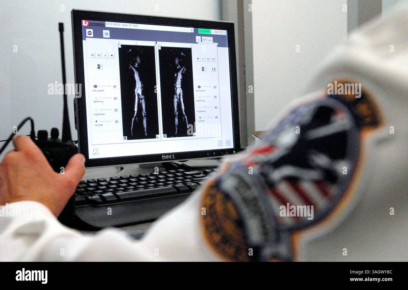 TSA officer Mark Martin views the passenger's image from a nearby ...