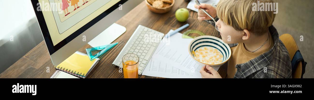 Child Eating Breakfast While Studying at Computer Stock Photo - Alamy