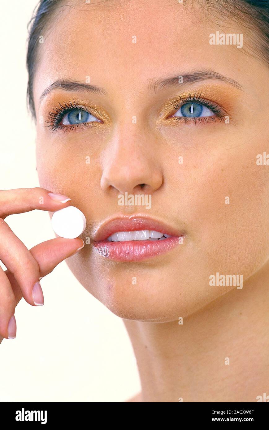 Close up of young woman taking pill, portrait Stock Photo - Alamy
