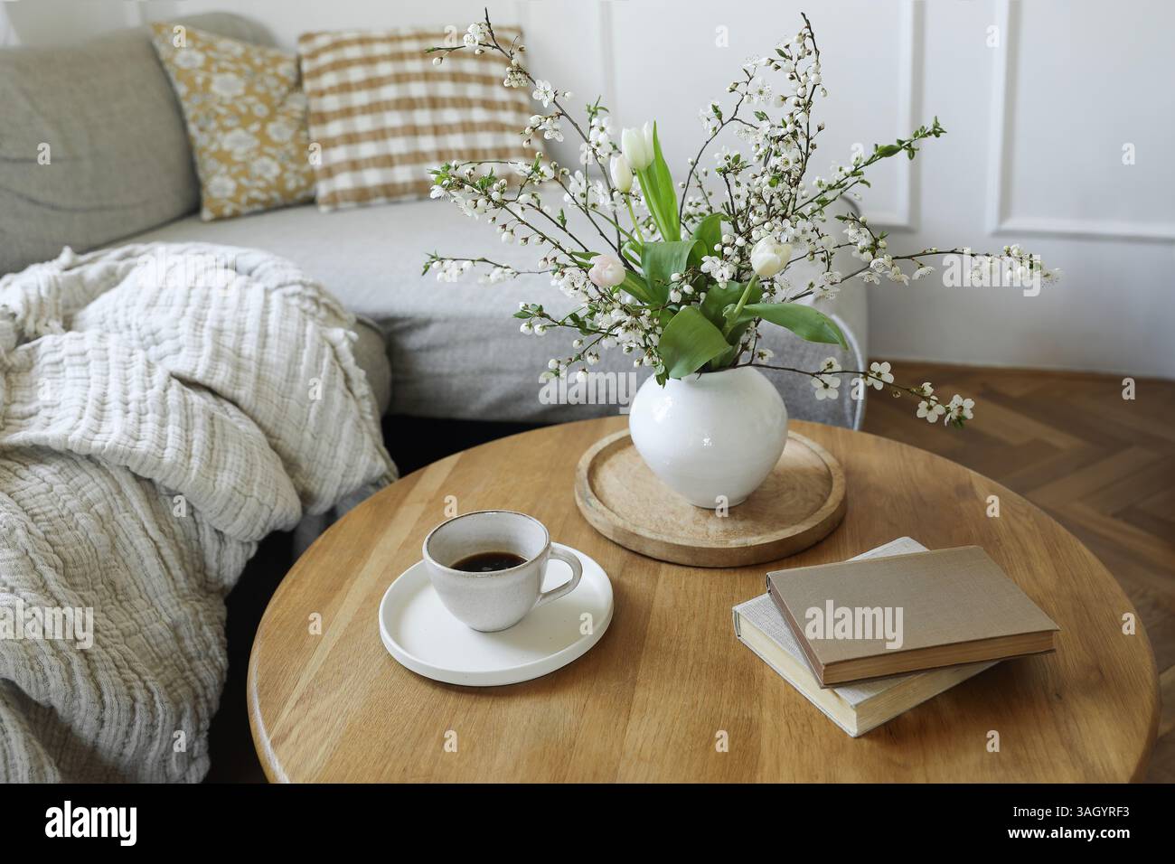 Spring interior still life. Cup of coffee, old books. Round wooden ...