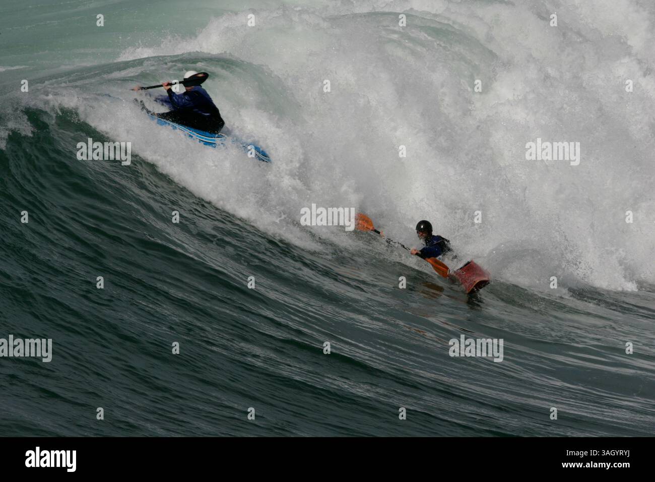 Kayaker JEFF LAXIER takes off on a wave in the surf break, but another ...