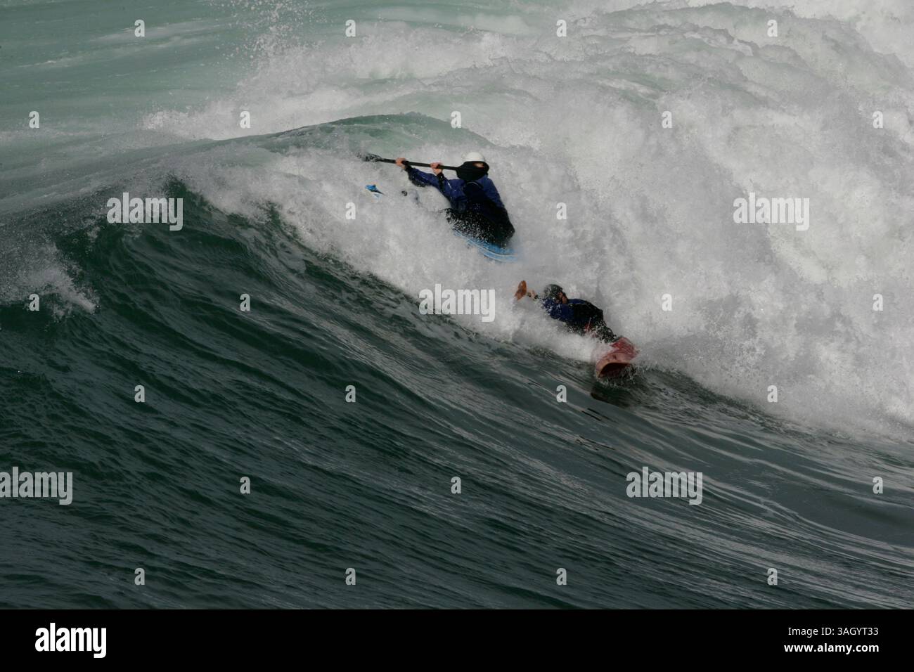 Kayaker Jeff Laxier takes off on a wave in the surf break, but another ...