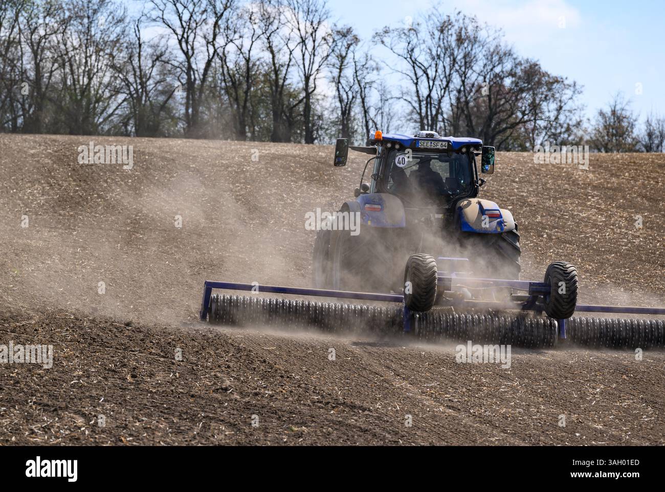 09 April 2025, Brandenburg, Podelzig: A farmer smoothes the dry soil ...