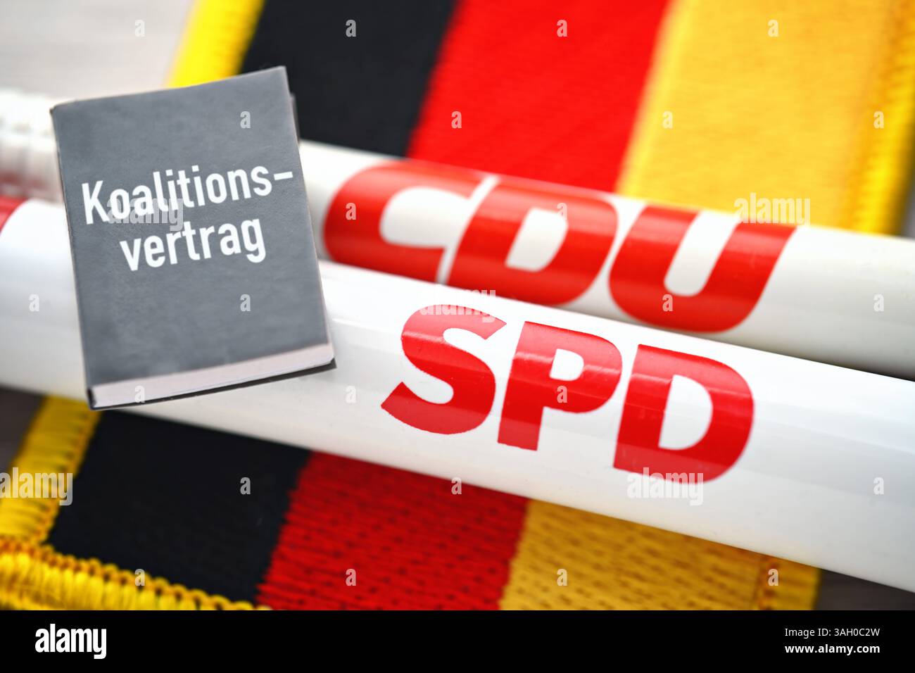 FOTOMONTAGE, Kugelschreiber von CDU und SPD auf Deutschlandfahne und ...