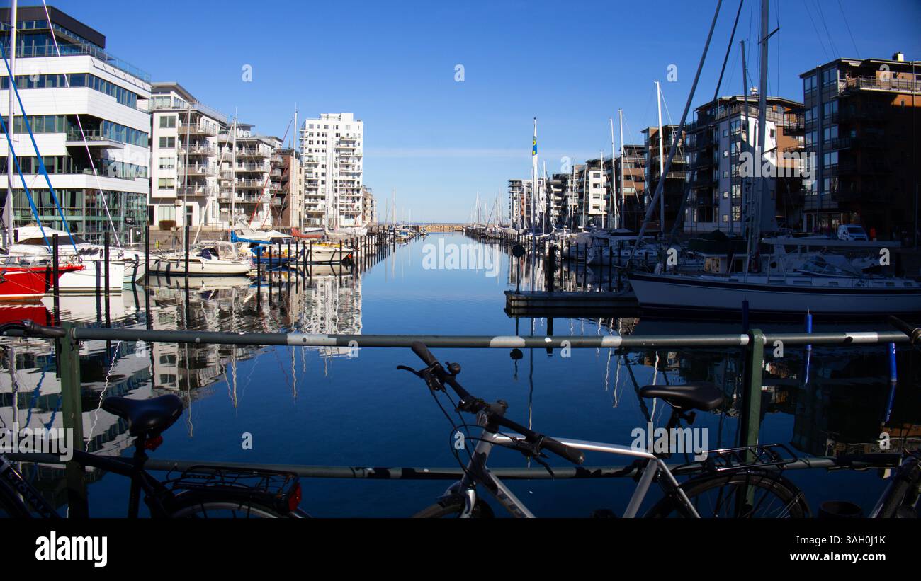 Sailing port of Malmo on a sunny day with boats docked and parked bikes ...