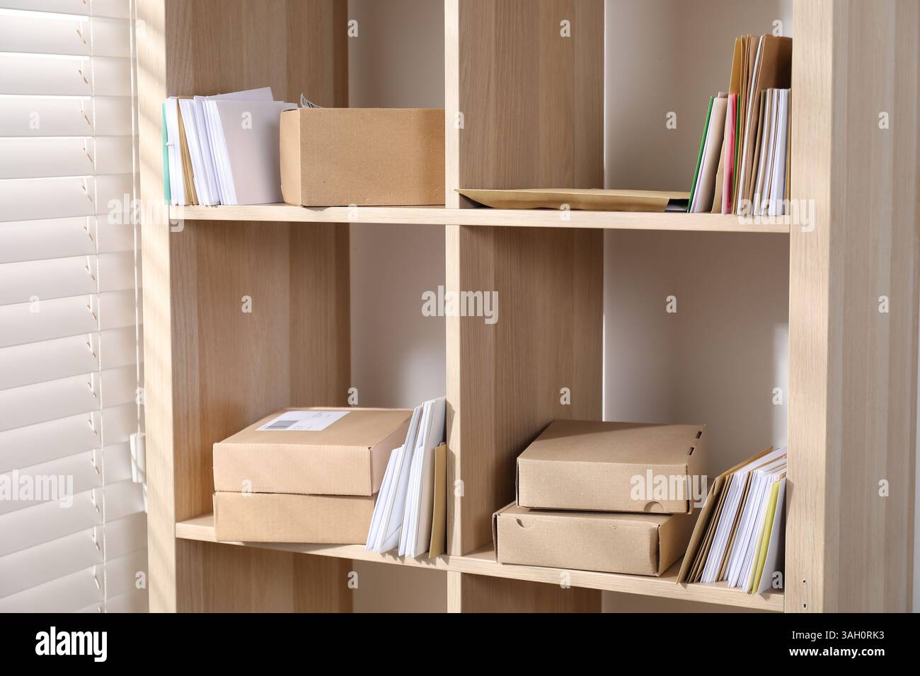 Different paper envelopes and parcels on wooden shelves in post office ...