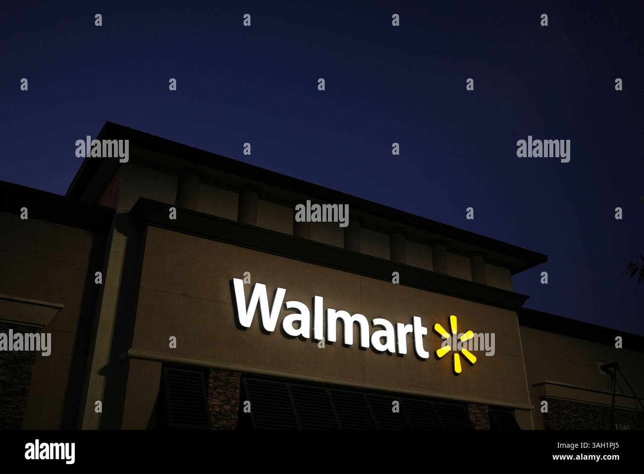 A Walmart sign is seen above the store entrance in the early morning ...