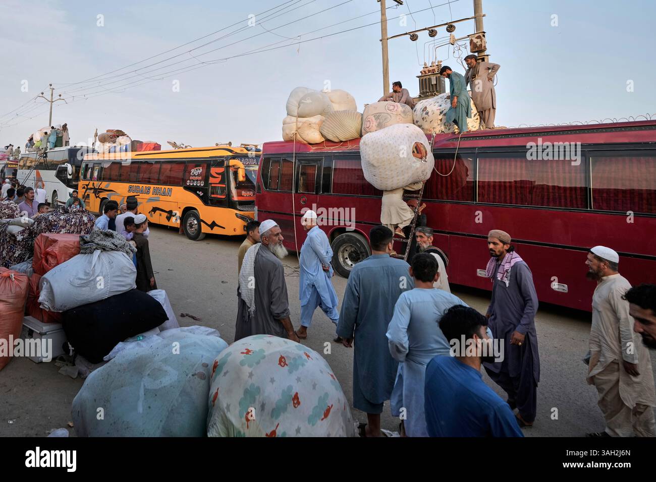 Afghan refugees wait to board in a bus to leave for their homeland ...