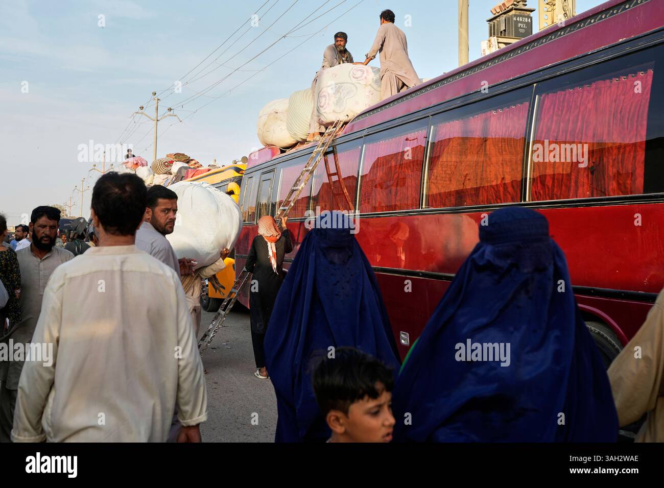 Afghan refugees board a bus to leave for their homeland Afghanistan, at ...